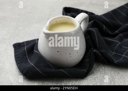 Condensed milk in jug on light grey table, top view Stock Photo - Alamy