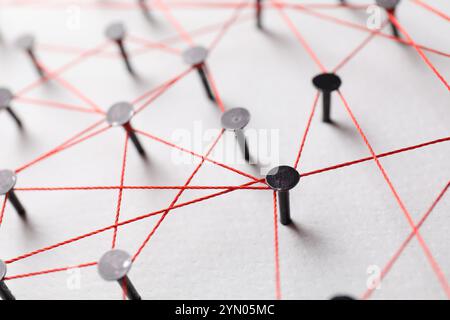 Network connection. Nails linked together by threads on white ...