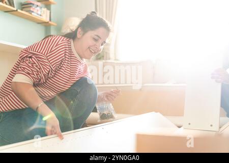 Beautiful young woman with manual assembling table at home Stock Photo ...
