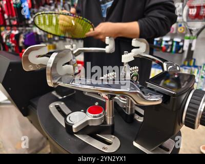 Strings a badminton racket on a racket stringing machine Stock Photo ...