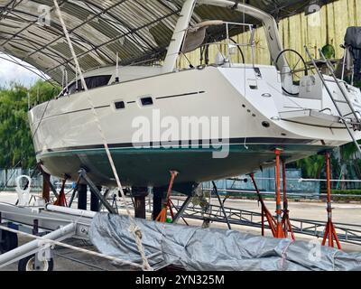 A boat is carefully lifted under a covered structure Stock Photo - Alamy