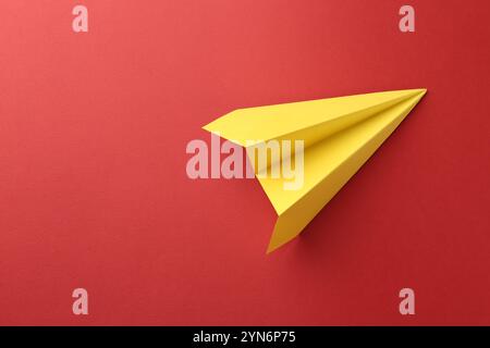 Yellow paper plane on red background Stock Photo - Alamy
