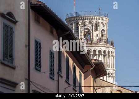 Famous leaning tower of Pisa, residential houses in front, Italy ...