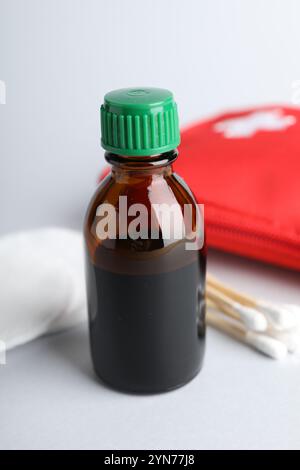 Topical iodine and other first aid kit components on light blue ...