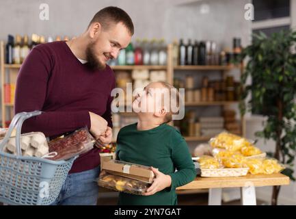 In supermarket man choose snacks Stock Photo - Alamy