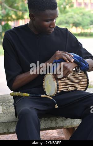 image of a Man playing the talking drum Stock Photo - Alamy