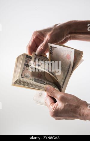 Counting 10,000 yen notes Stock Photo - Alamy