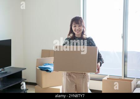 Woman in her 20s carrying a packed parcel Stock Photo - Alamy