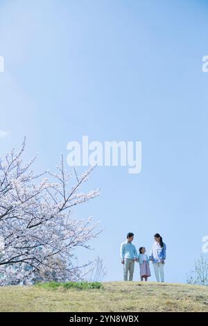 Happy family standing under a cherry tree Stock Photo - Alamy