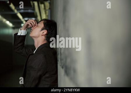 Man crouching and pondering in dark corridor Stock Photo - Alamy