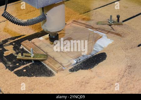 Milling machine cutting wooden workpiece from wood pulp at technology ...