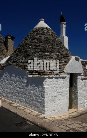 Whitewashed walls and roof cone of restored trullo, a traditional ...