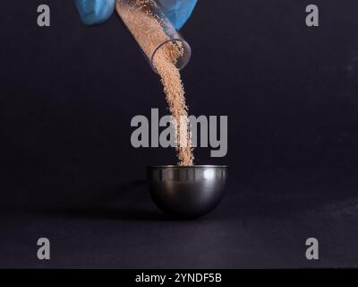 powder grains fall on a pile of powder on a dark background Stock Photo ...