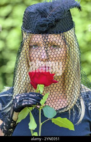 A young, grieving widow with a veil and rose. Death and inheritance ...