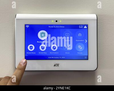 A person using an ADT security touch screen panel control on a wall ...