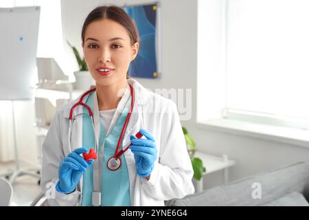 Female Asian endocrinologist with thyroid gland model in clinic Stock ...