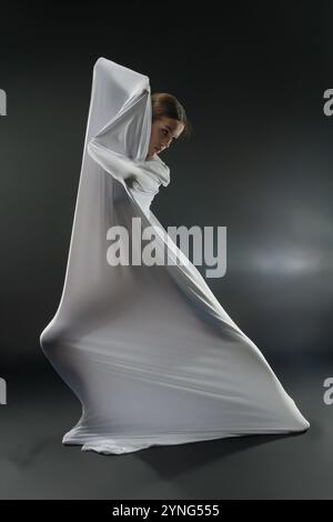A flowing figure draped in soft fabric, captured in a moment of grace ...