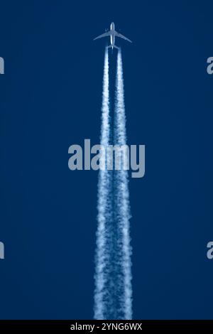 Commercial airplane with jet stream overhead view with blue background ...