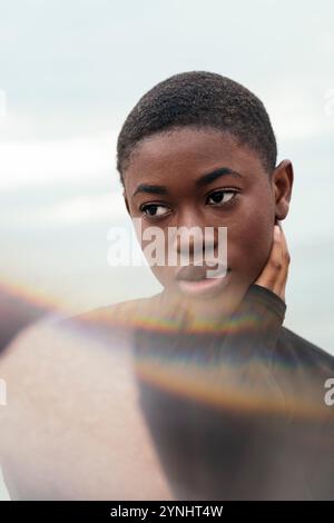 Young contemplative ethnic female with short hair touching face in ...