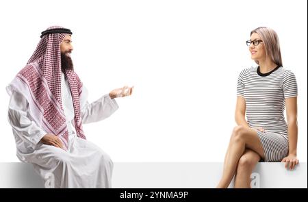 Young beautiful arab woman listening to music sitting on sofa at home ...