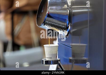 Fresh espresso dripping into a Nespresso-branded paper cup Stock Photo ...