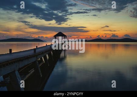 A jetty in the sunset on Coron Island with a small hut at the end and ...