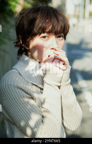 Woman in her 20s warming her biting hands Stock Photo - Alamy