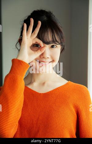 Smiling 20s woman giving the ‘okaye’ sign Stock Photo - Alamy