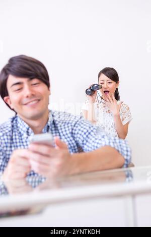 Man fiddling with his phone and woman looking behind him Stock Photo ...