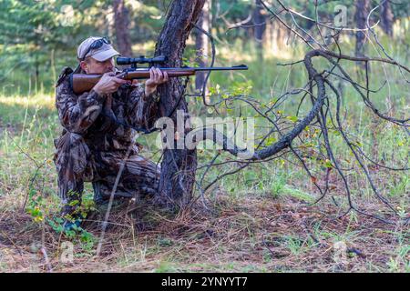 Hunter looking through scope of rifle Stock Photo - Alamy