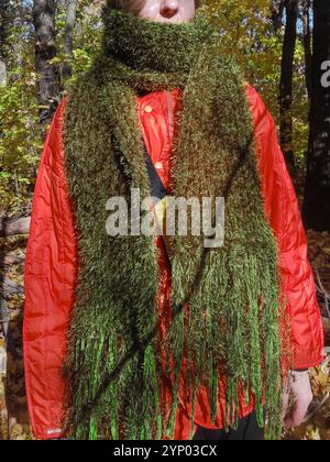 Knitted scarf in white. Women's handmade knitted clothes. Nearby is a ...