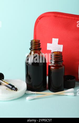 Topical iodine and other first aid kit components on light grey ...