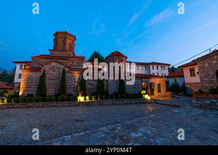 Cobblestone courtyard and illuminated buildings of Saint Naum monastery ...