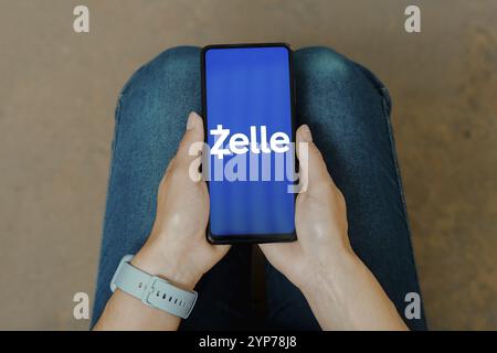 In this photo illustration, Zelle logo is seen on a smartphone and on a ...