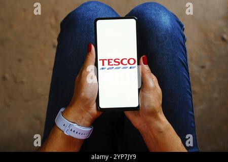 In this photo illustration, the logo of Tesco is displayed on the ...