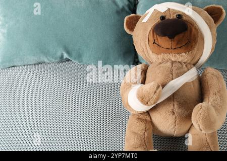 Cute teddy bear with bandages and adhesive medical plasters on bed ...