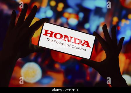 In this photo illustration a Honda logo seen displayed on a smartphone ...