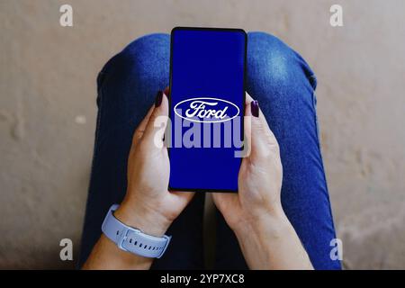 In this photo illustration, the Ford logo is seen displayed on a mobile ...