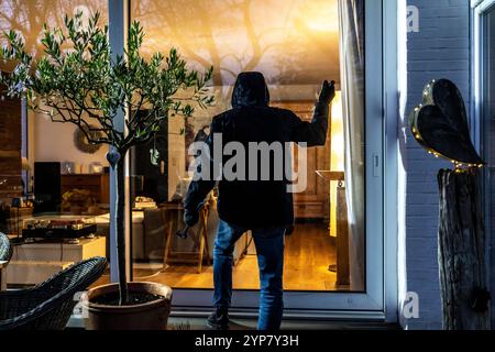 Symbolic image of a burglary, perpetrator spying on an apartment from ...