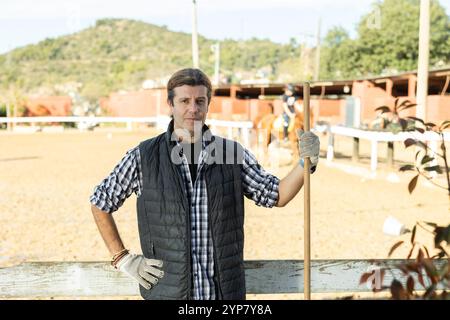 Owner of the stable poses in front of corral for horses Stock Photo - Alamy