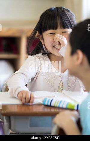 Primary schools students chatting in classroom Stock Photo - Alamy