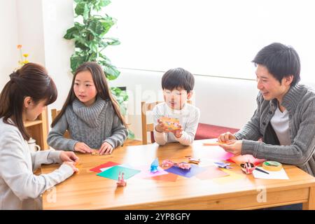 Father and child girl doing origami crafts together. Modern parenthood ...