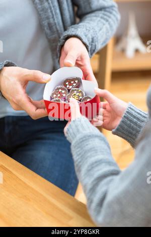 Daughter handing chocolate to father Stock Photo - Alamy