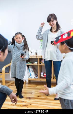 Family members throwing beans on Setsubun Stock Photo - Alamy