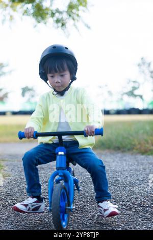 Boy riding kick bike Stock Photo - Alamy