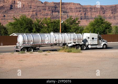large american truck pulling a chrome liquid tanker moving along a ...