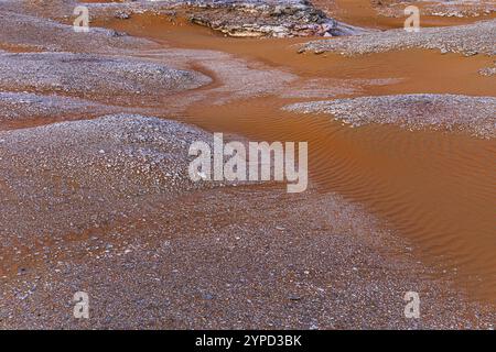 Striking rocks surrounded by windswept sand structures, sparse ...