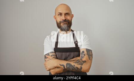 Hispanic man with tattoos standing over blue background clueless and ...