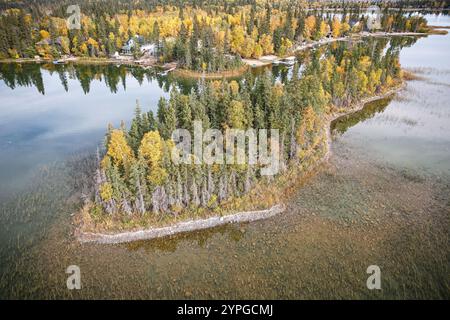 A small calm lake surrounded by rocky mountains and trees Stock Photo ...