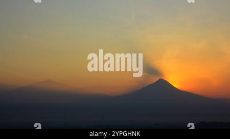 Silhouette of Mount Merapi with a red-orange sky at sunrise. The ...